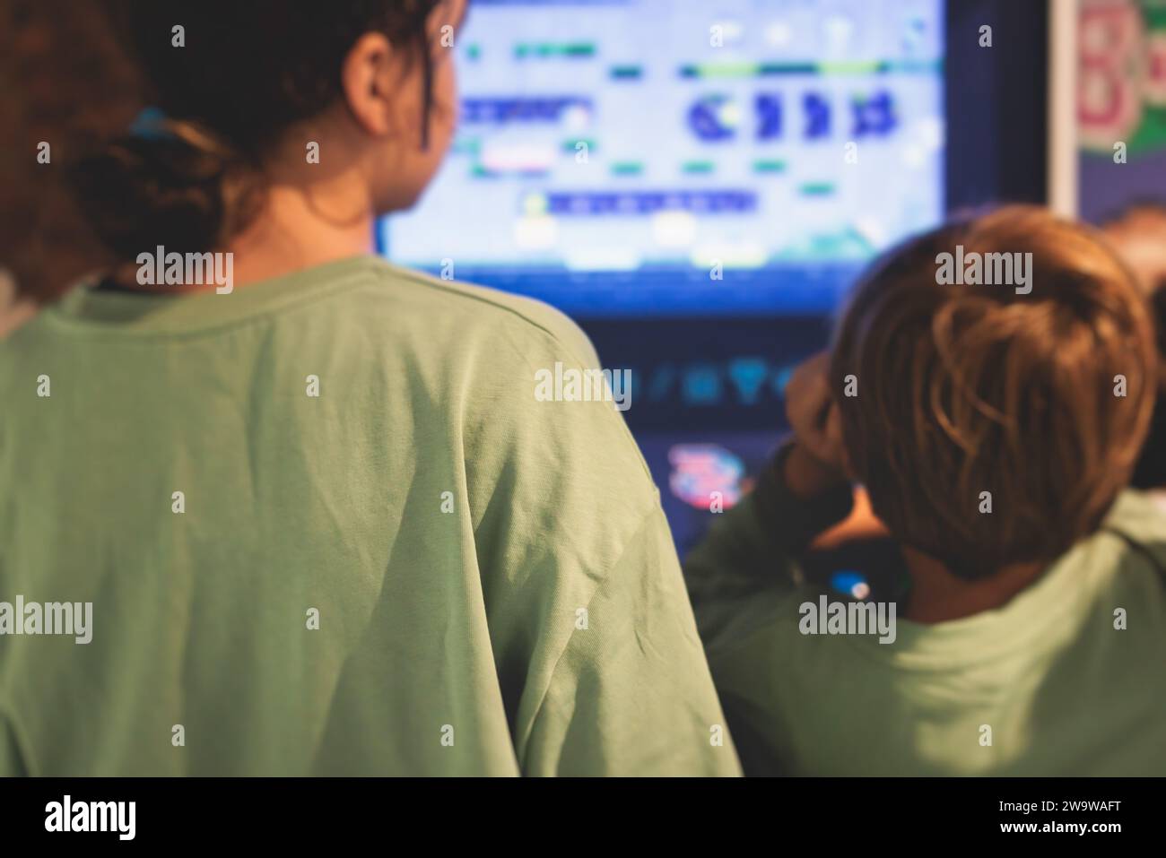 Kids play slot machine at amusement theme park, children play arcade ...