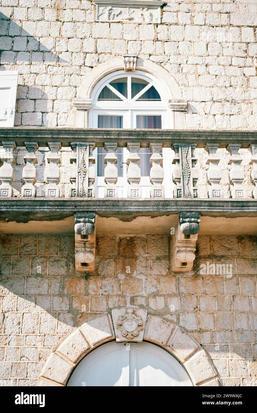 Carved stone balustrade of the balcony of an ancient house with a coat ...