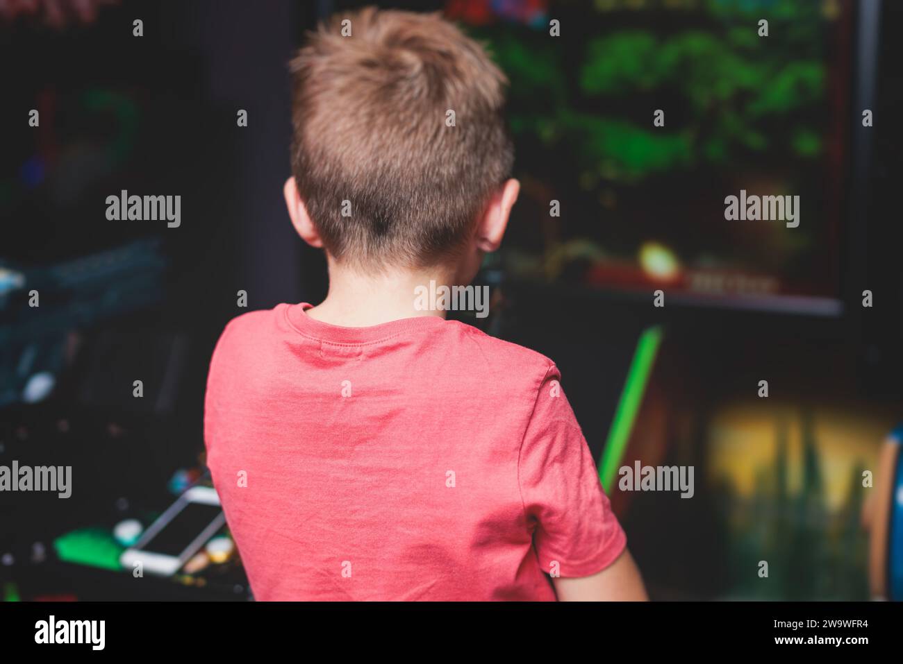 Kids play slot machine at amusement theme park, children play arcade ...