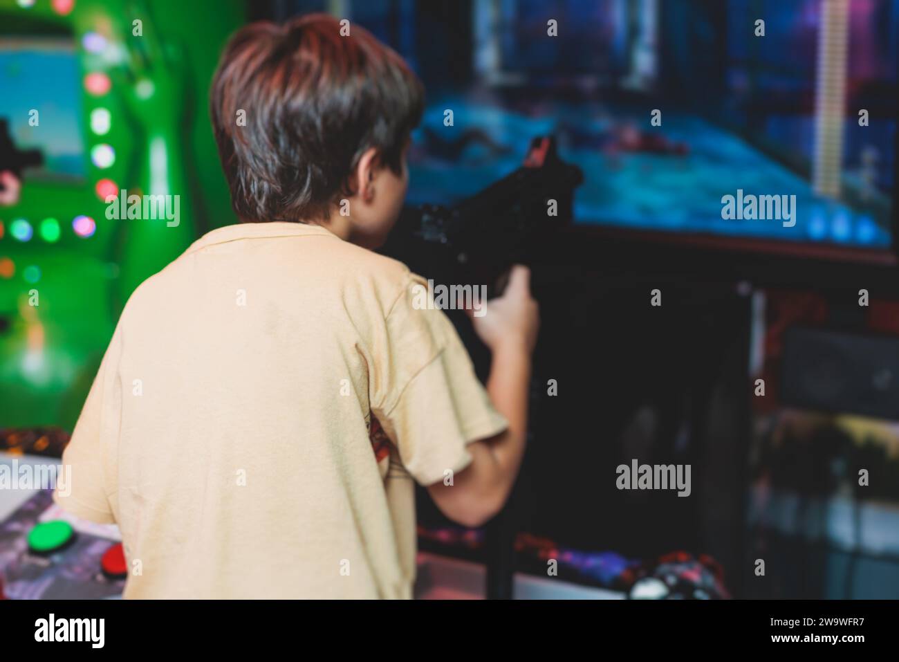 Kids play slot machine at amusement theme park, children play arcade ...