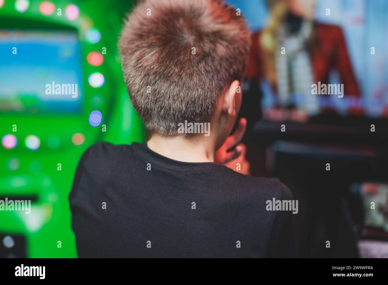 Kids play slot machine at amusement theme park, children play arcade ...