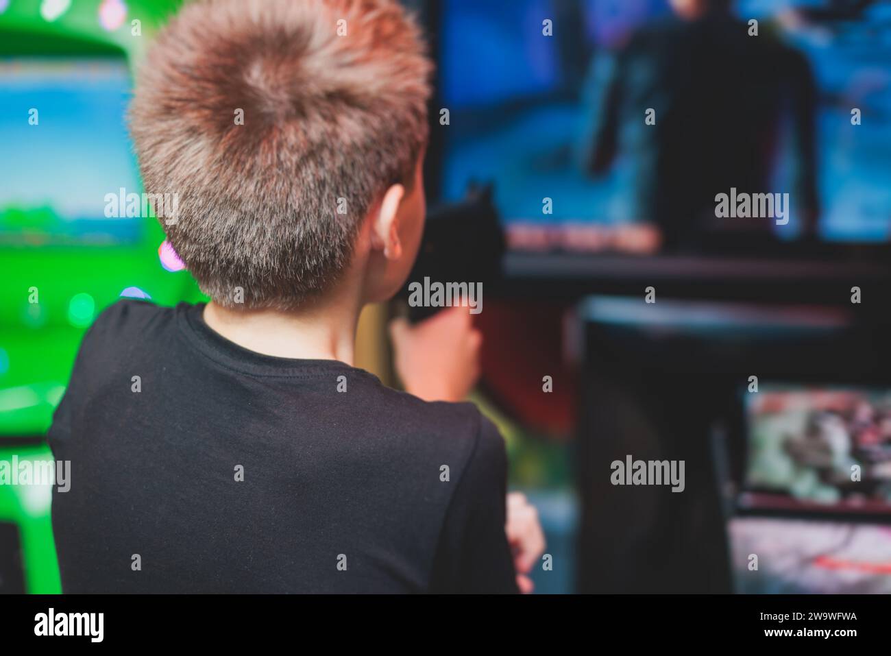 Kids play slot machine at amusement theme park, children play arcade ...