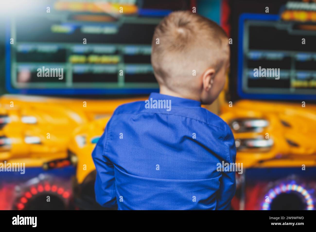 Kids play slot machine at amusement theme park, children play arcade ...