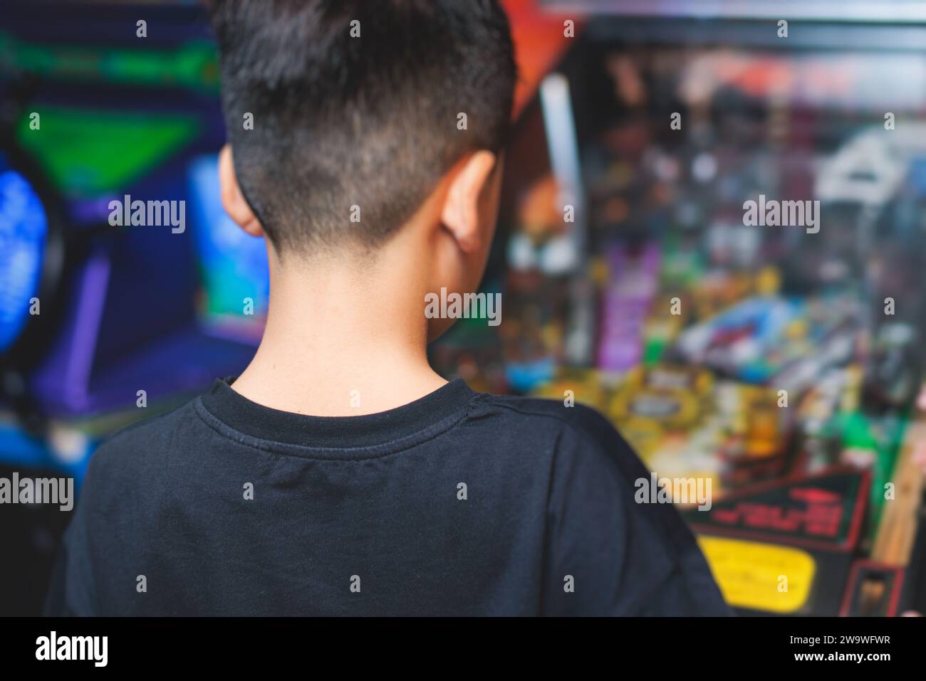 Kids play slot machine at amusement theme park, children play arcade ...