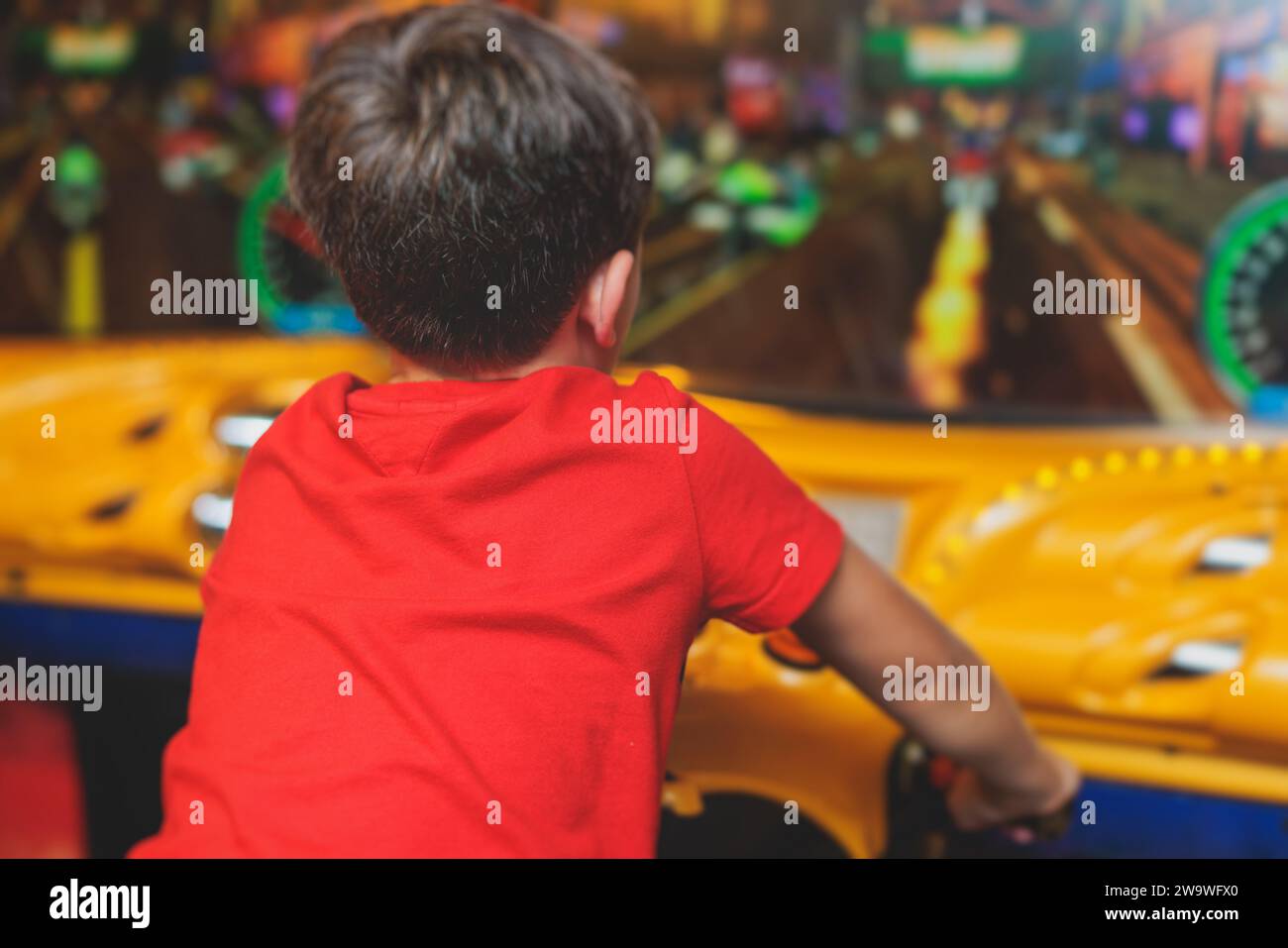 Kids play slot machine at amusement theme park, children play arcade ...