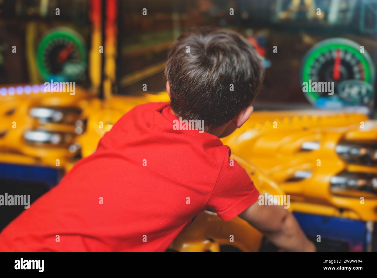 Kids play slot machine at amusement theme park, children play arcade ...