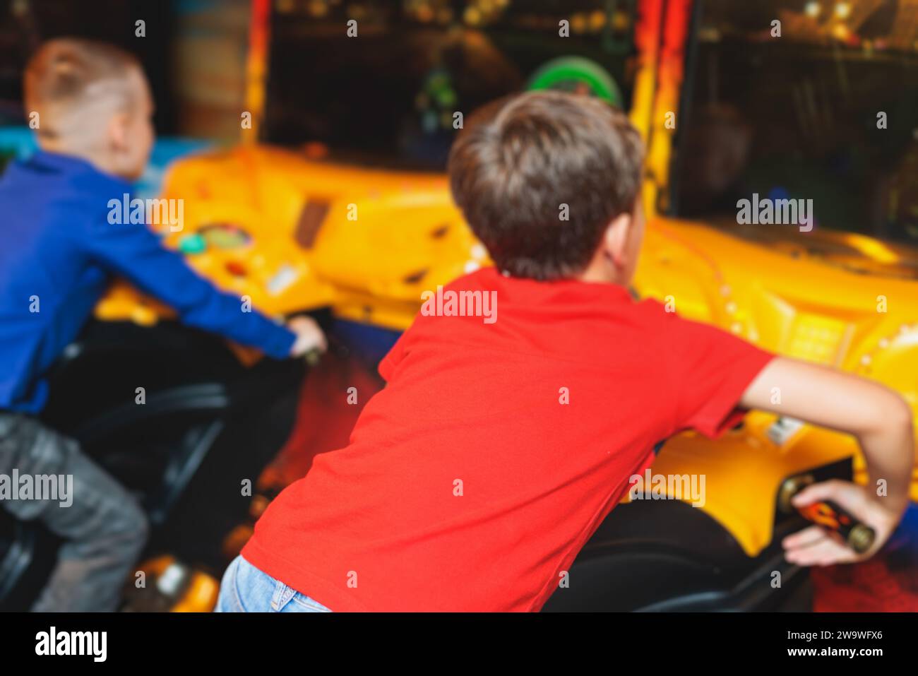 Kids play slot machine at amusement theme park, children play arcade ...