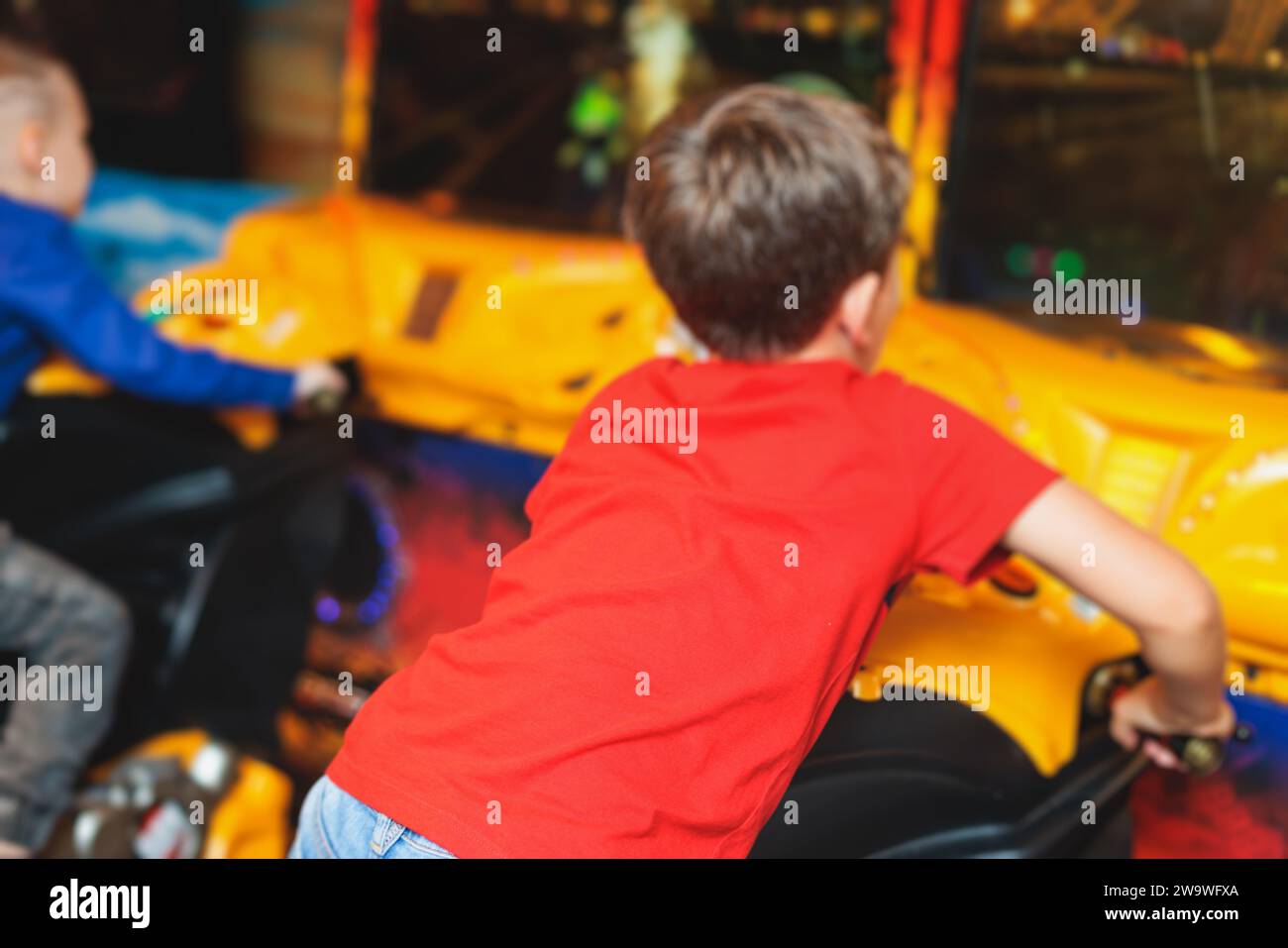 Kids play slot machine at amusement theme park, children play arcade ...