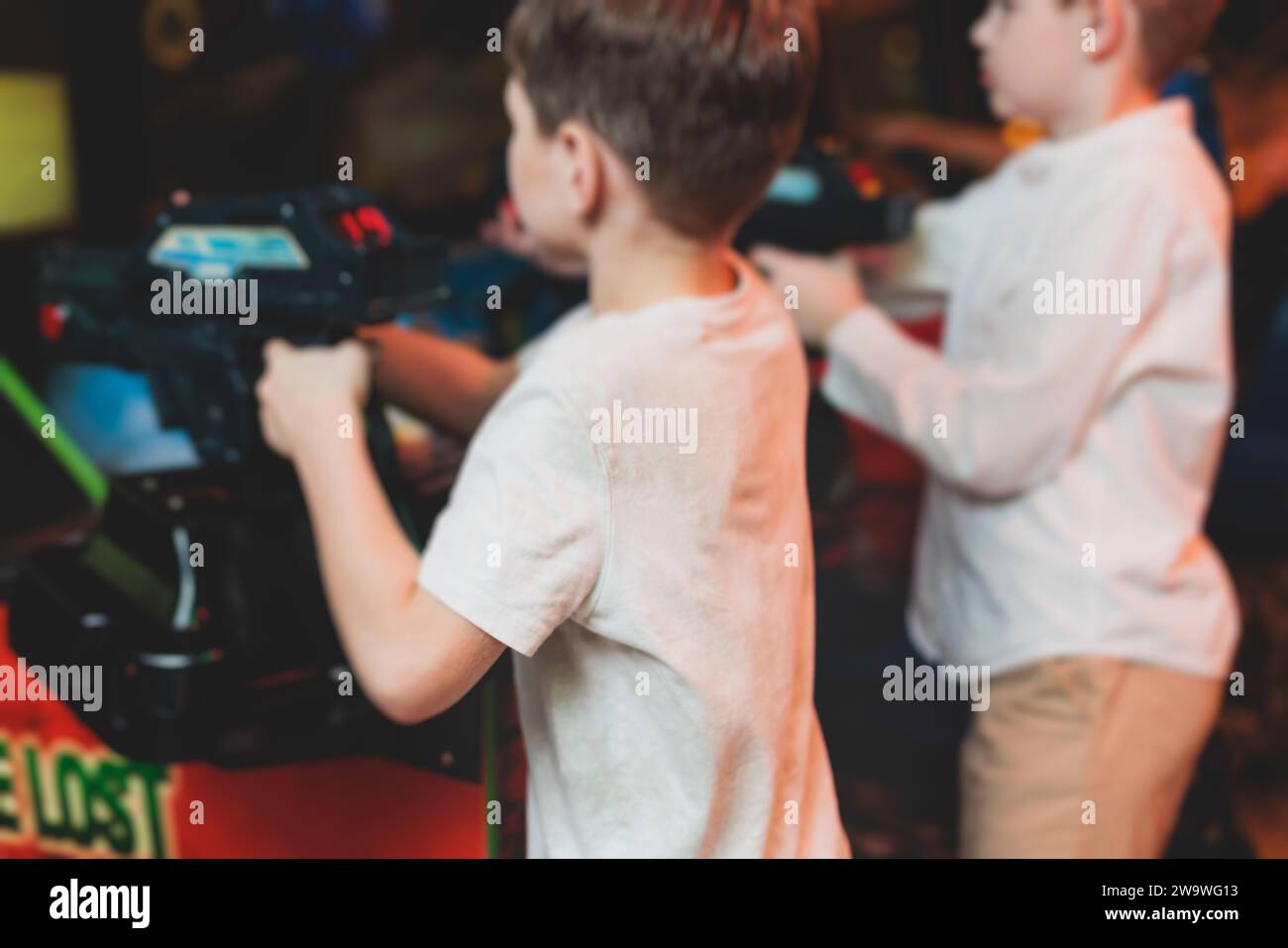 Kids play slot machine at amusement theme park, children play arcade ...