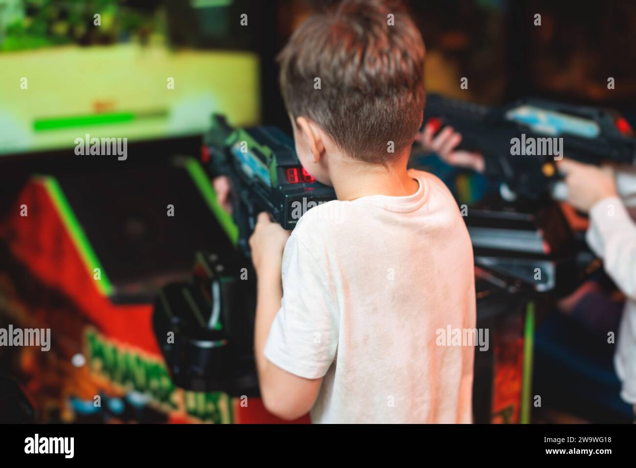 Kids play slot machine at amusement theme park, children play arcade ...