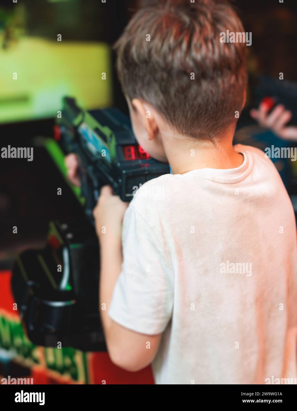 Kids play slot machine at amusement theme park, children play arcade ...