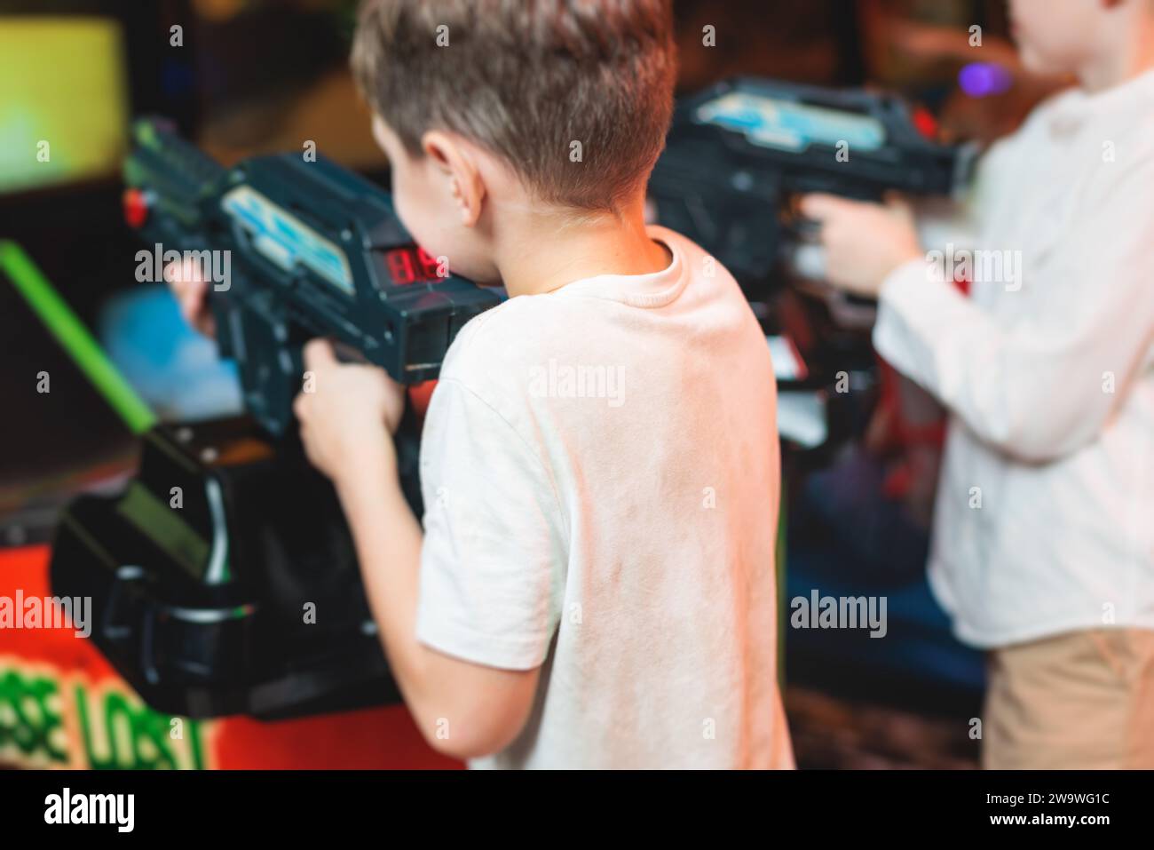 Kids play slot machine at amusement theme park, children play arcade ...