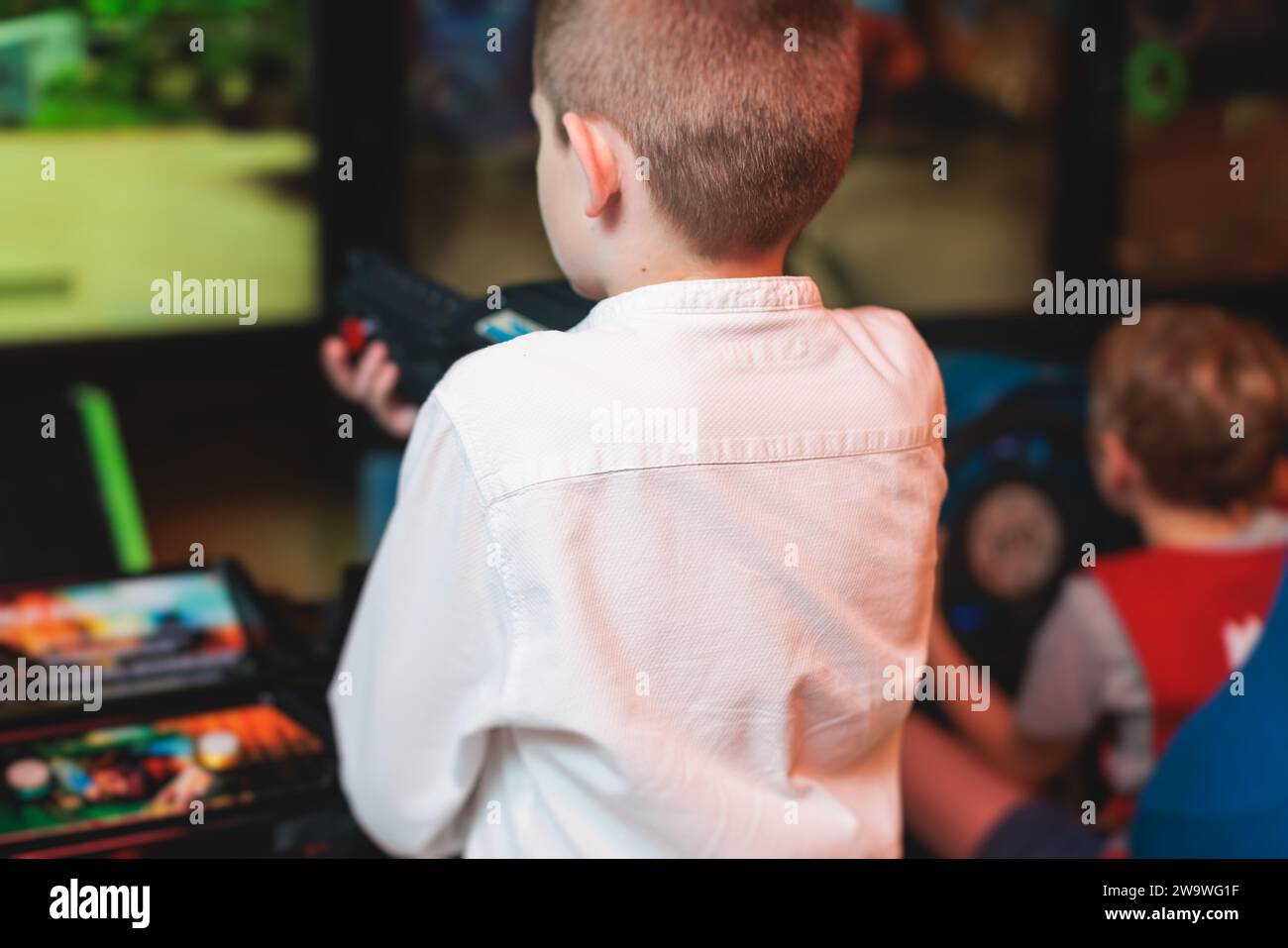 Kids play slot machine at amusement theme park, children play arcade ...