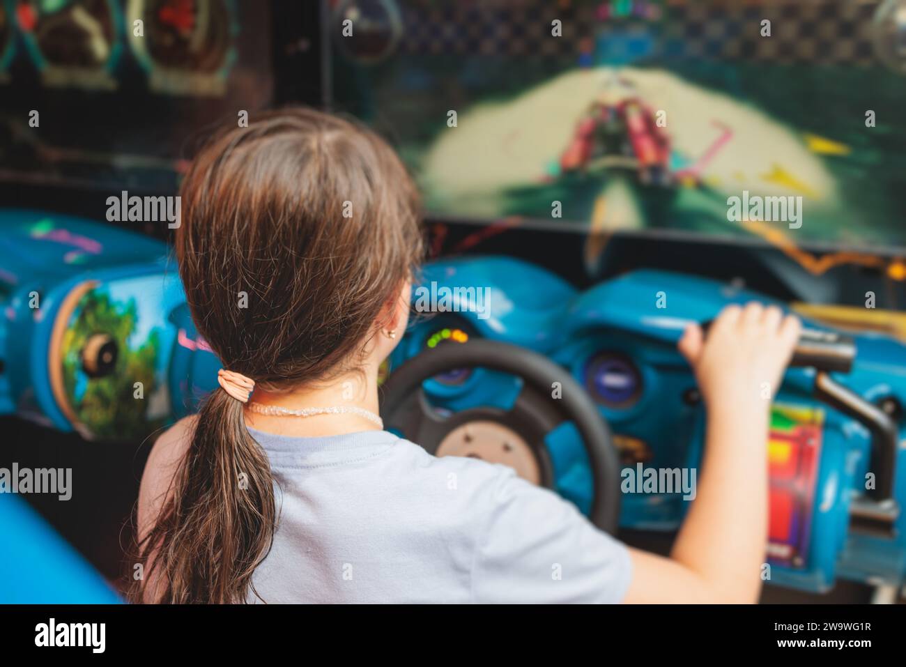 Kids play slot machine at amusement theme park, children play arcade ...