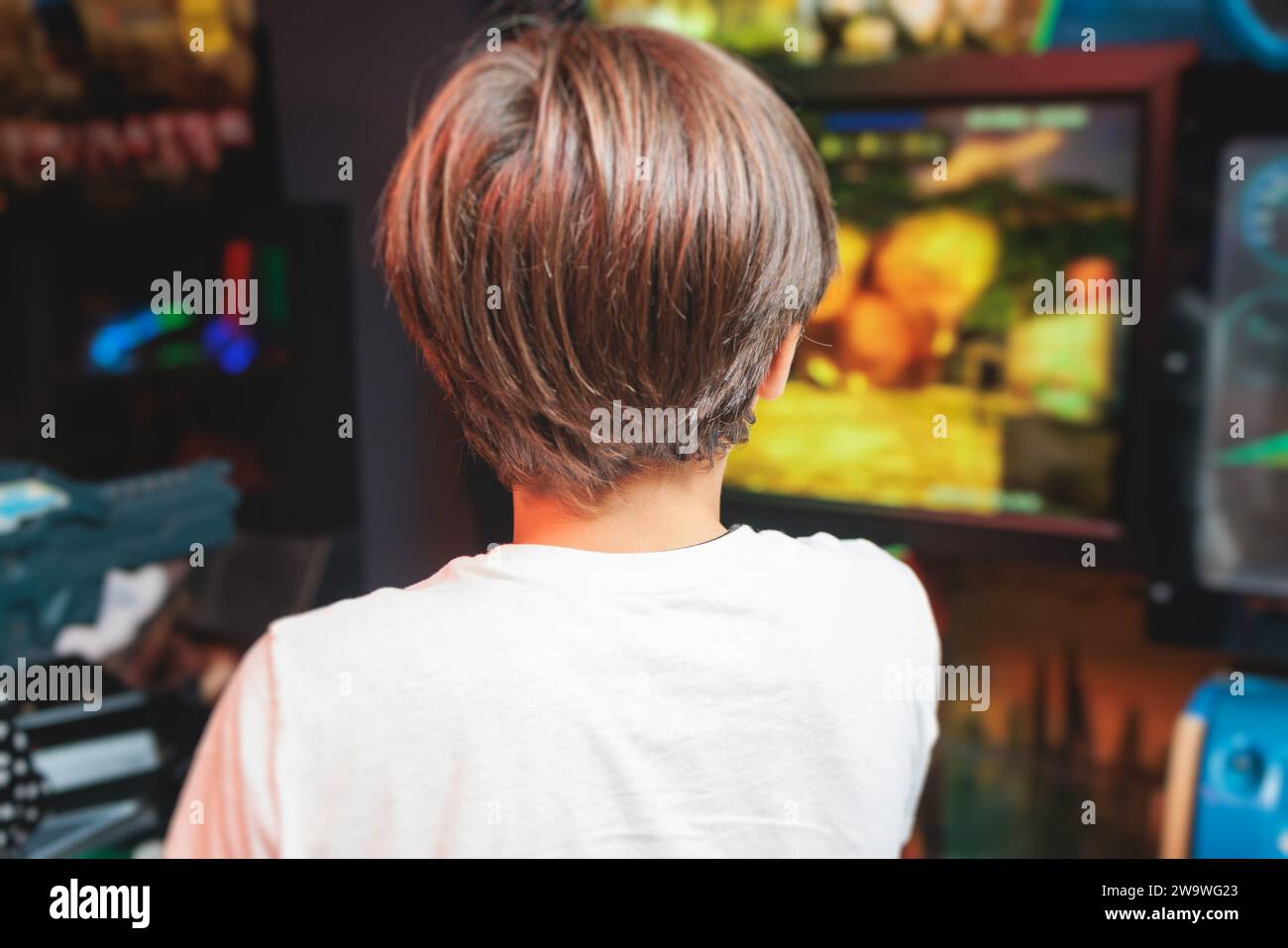 Kids play slot machine at amusement theme park, children play arcade ...