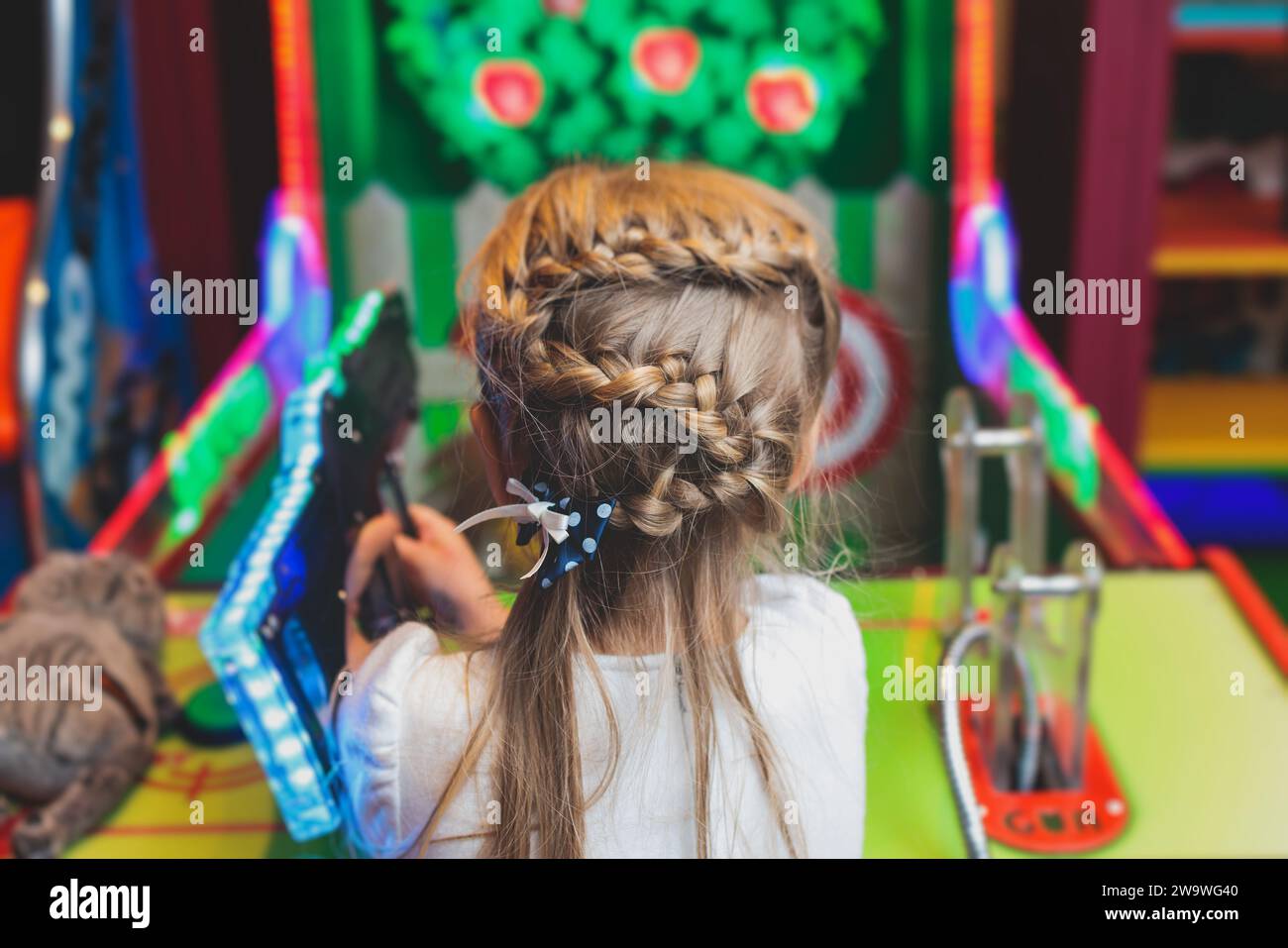 Kids play slot machine at amusement theme park, children play arcade ...