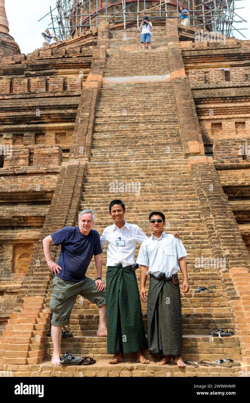 Tourist, guide, and driver post in front of a pagoda in Bagan Myanmar ...