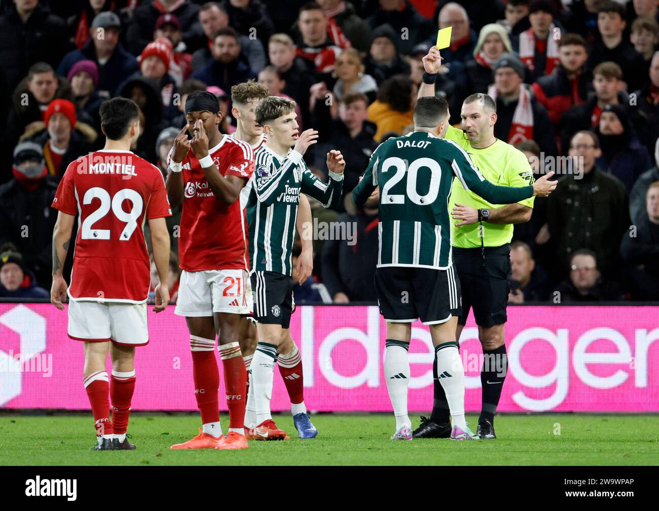 Manchester United's Diogo Dalot (second right) is shown a yellow card ...