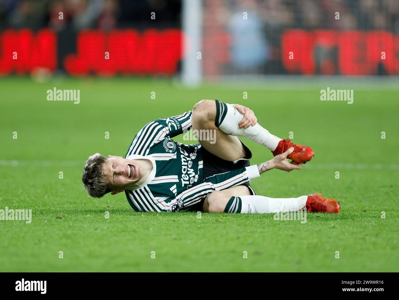 Manchester United's Alejandro Garnacho holds his foot after taking a ...