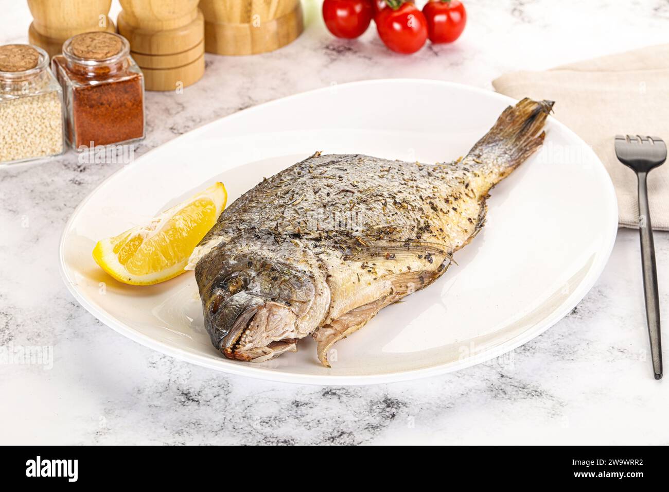 Baked Dorado fish served lemon slice Stock Photo - Alamy