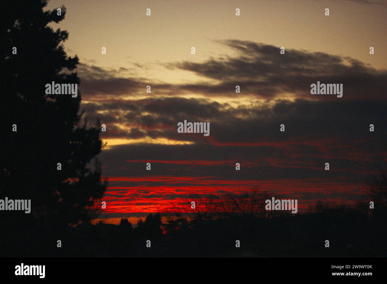 Gloomy red gray sky with dark low clouds on a horizon at the end of a ...