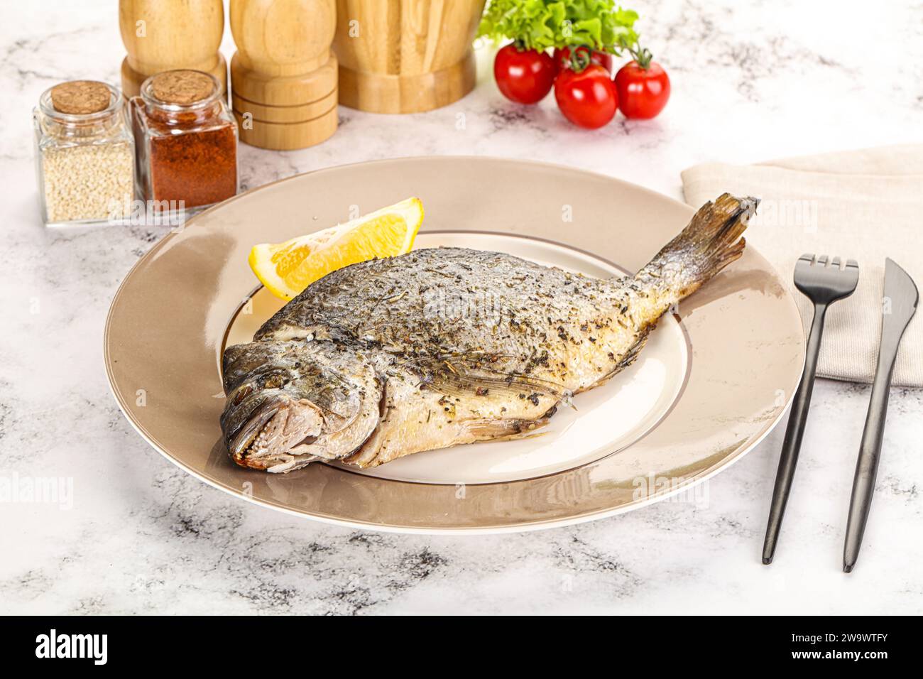 Baked Dorado fish served lemon slice Stock Photo - Alamy