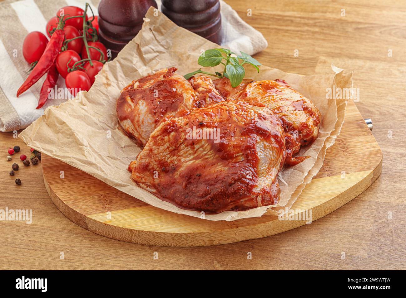 Marinated chicken leg thighs in tomato sauce Stock Photo - Alamy