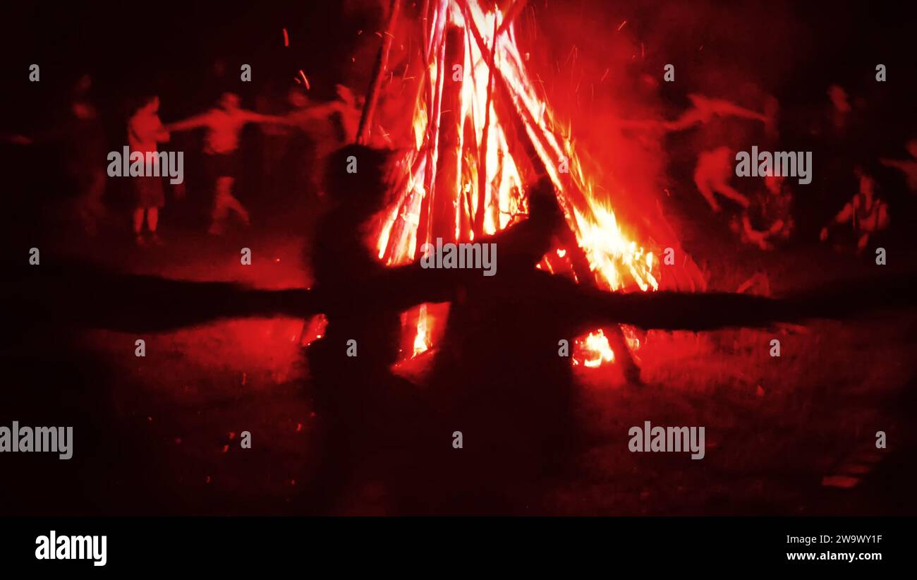 Huge fire at night and young people around. Pagan festival of Walpurgis ...