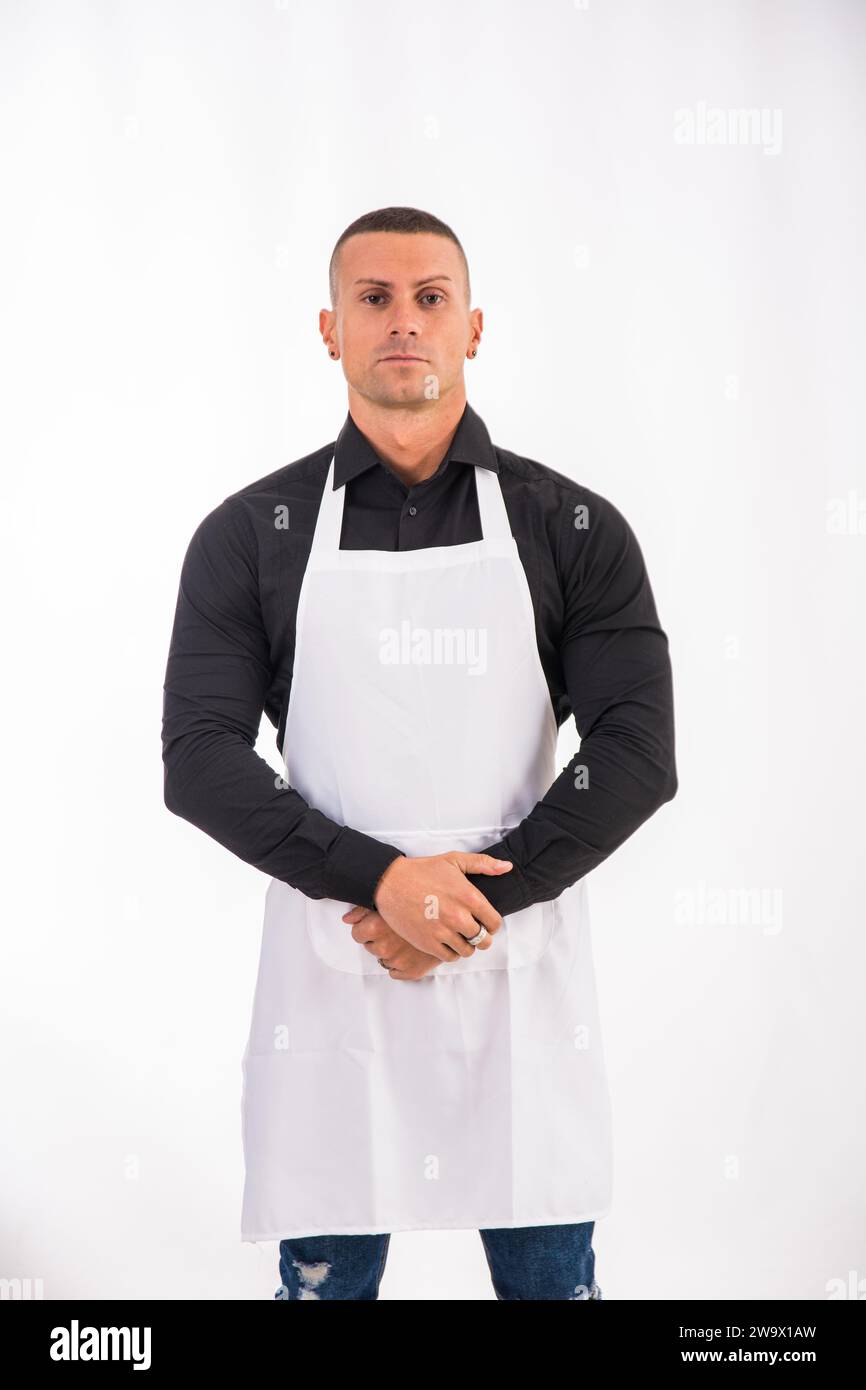 Attractive chef or waiter posing, wearing white apron and black shirt ...