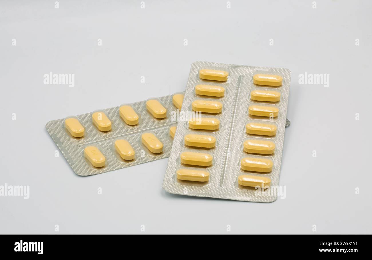 Medical yellow tablets in blisters closeup against white Stock Photo ...