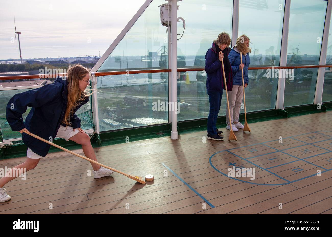 People playing shuffleboard on the deck of a cruise ship with a wind ...