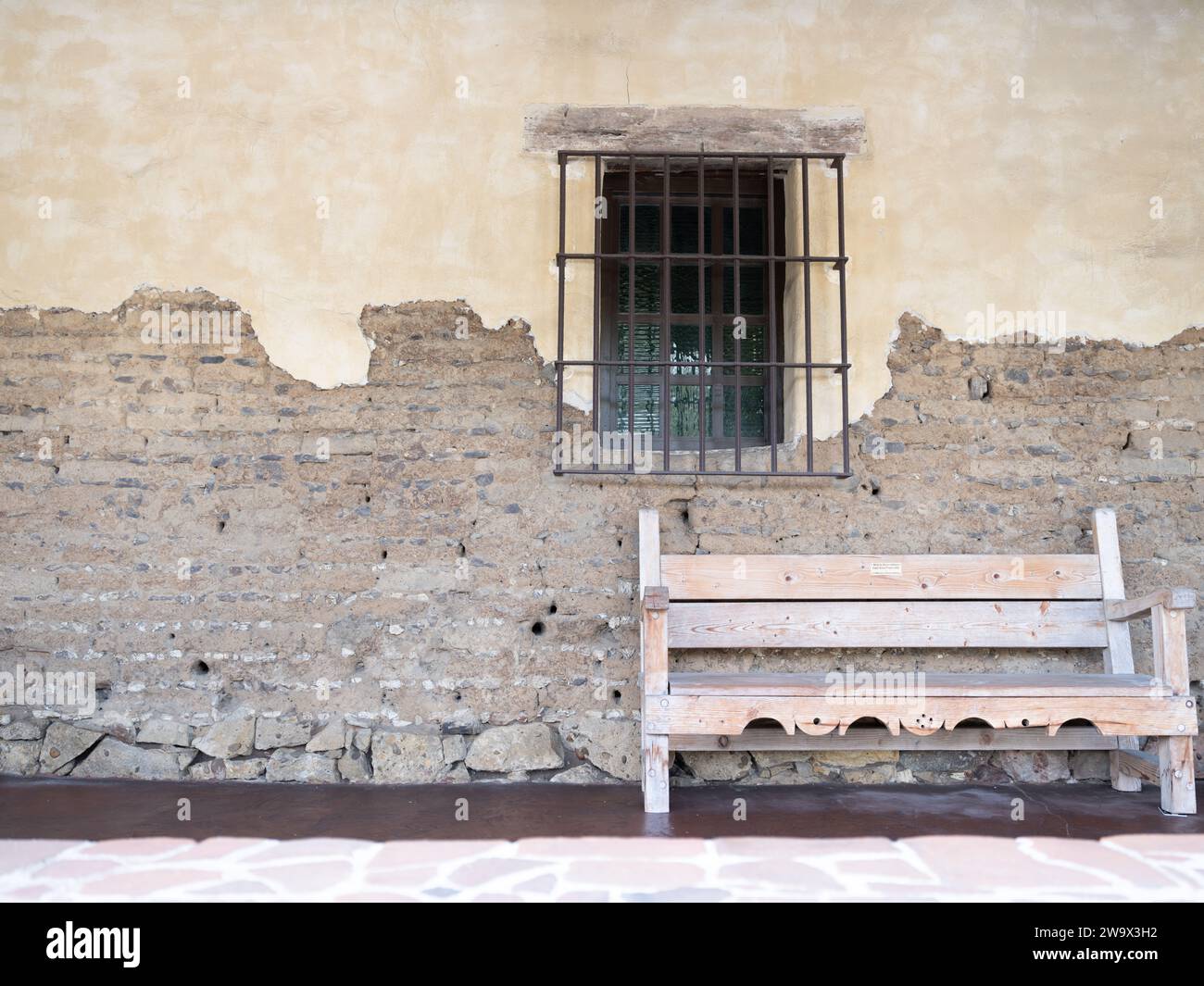 Old California mission wall with bricks, bench and window Stock Photo ...