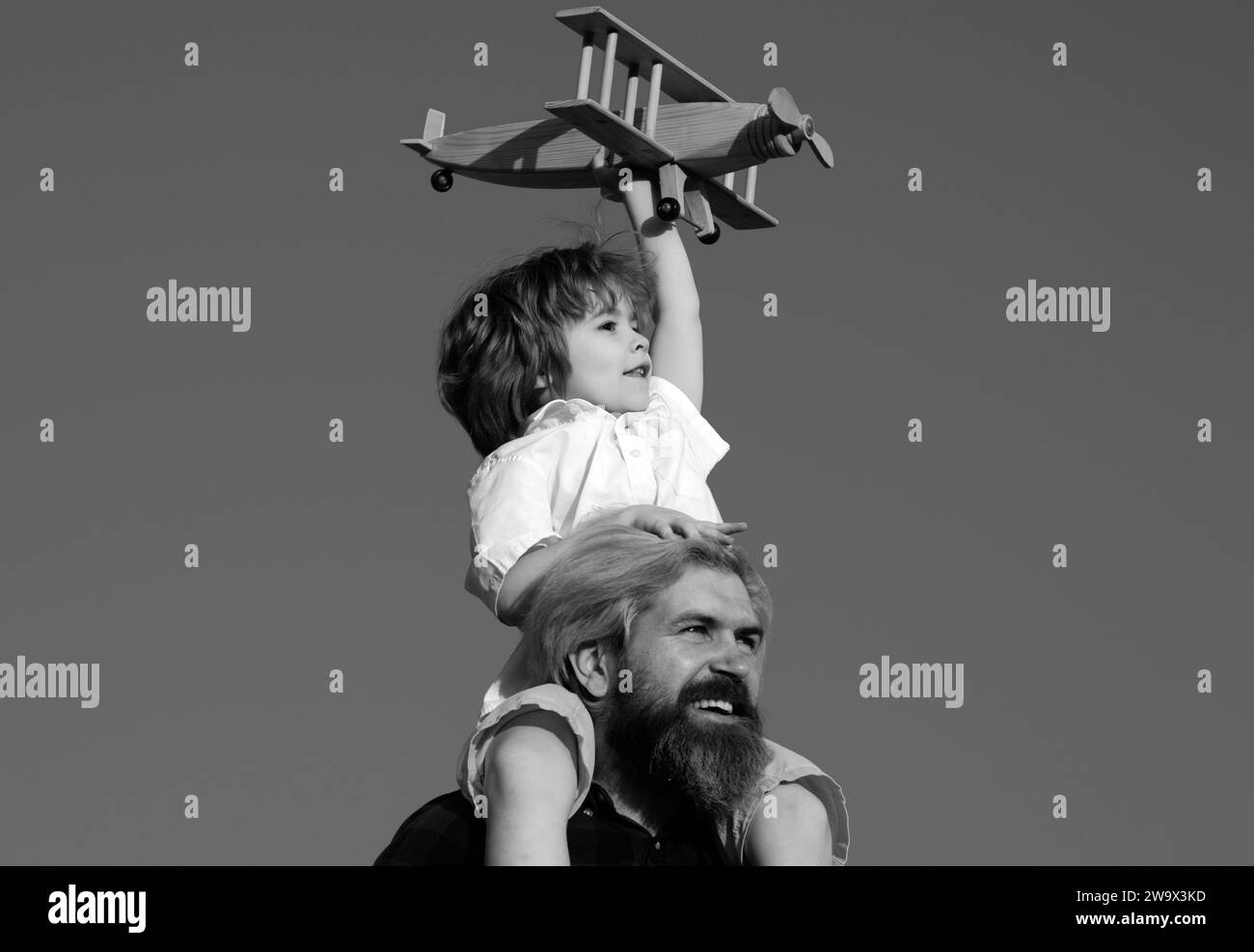 Boy with airplane sitting on fathers shoulders. Father and son together ...