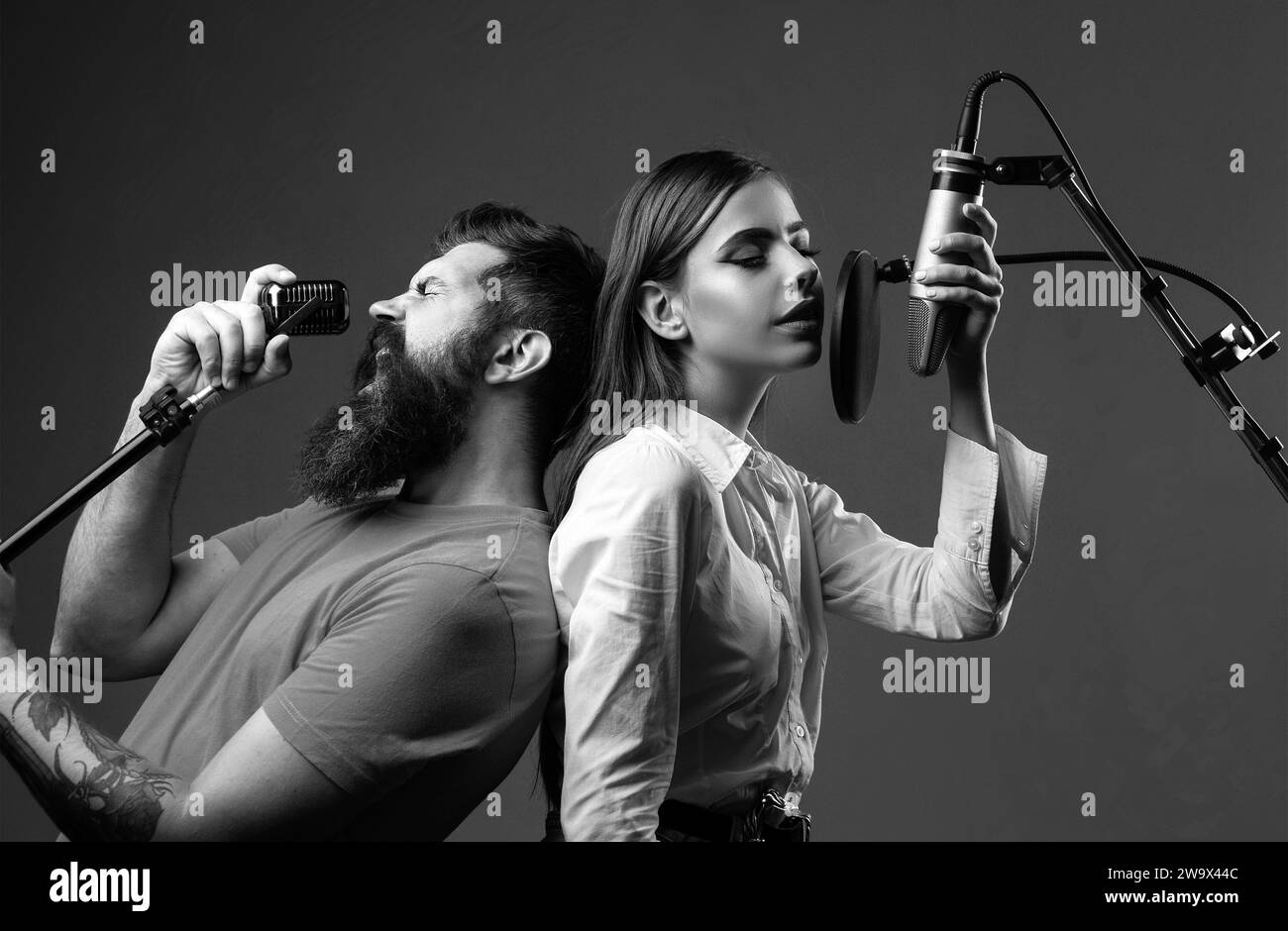 Man and woman with excited faces enjoy music. Singer couple is ...