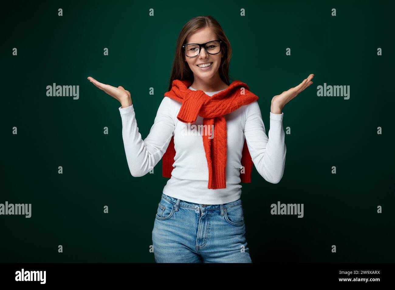 Smart young woman tied a red sweater over her shoulders and waves her ...