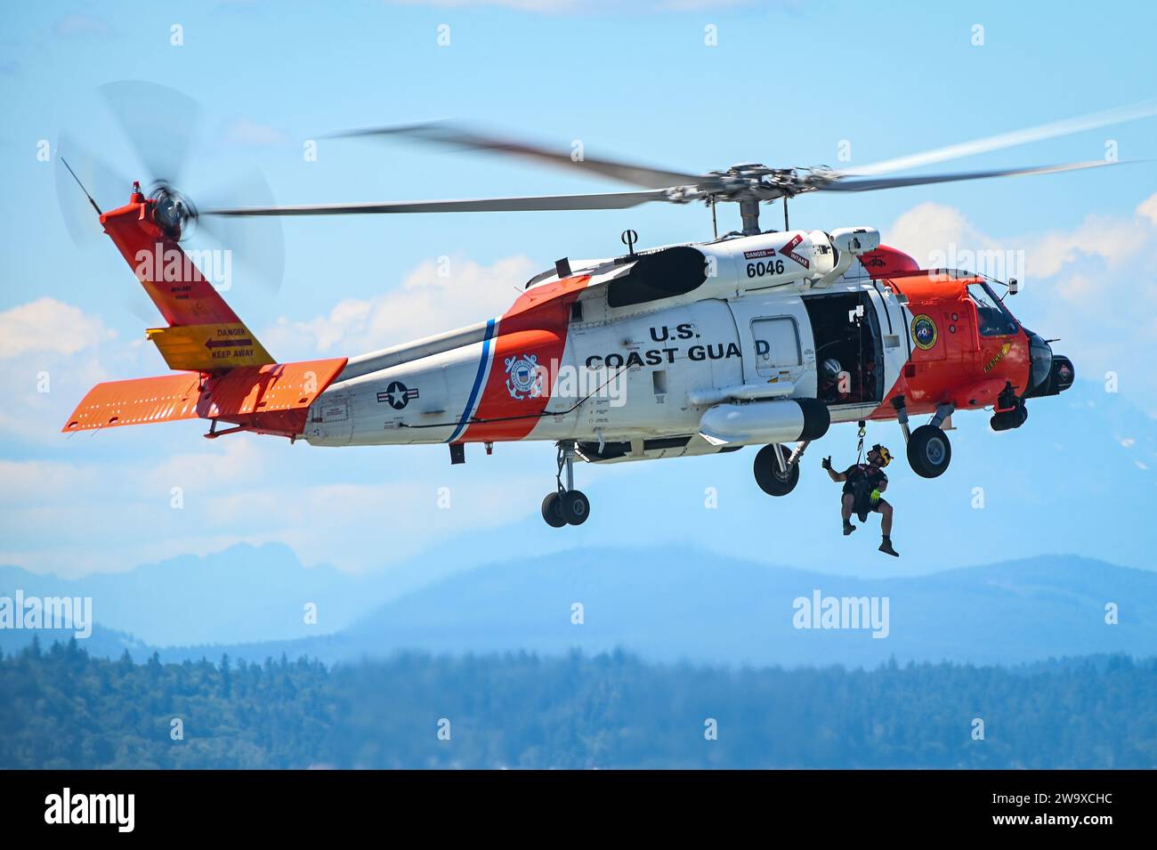 A Coast Guard rescue swimmer from Air Station Astoria dangles below an ...