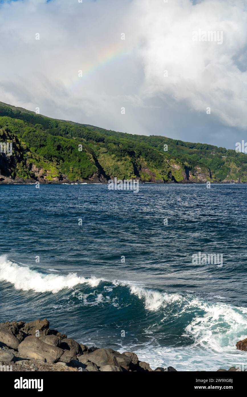 A brilliant rainbow stretches across the sky above the coastal cliffs ...