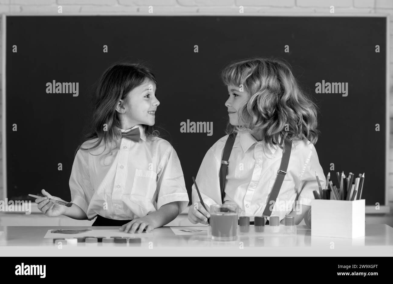 School children drawing a colorful pictures with pencil crayons in ...