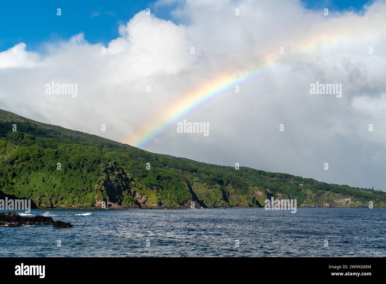 A brilliant rainbow stretches across the sky above the coastal cliffs ...