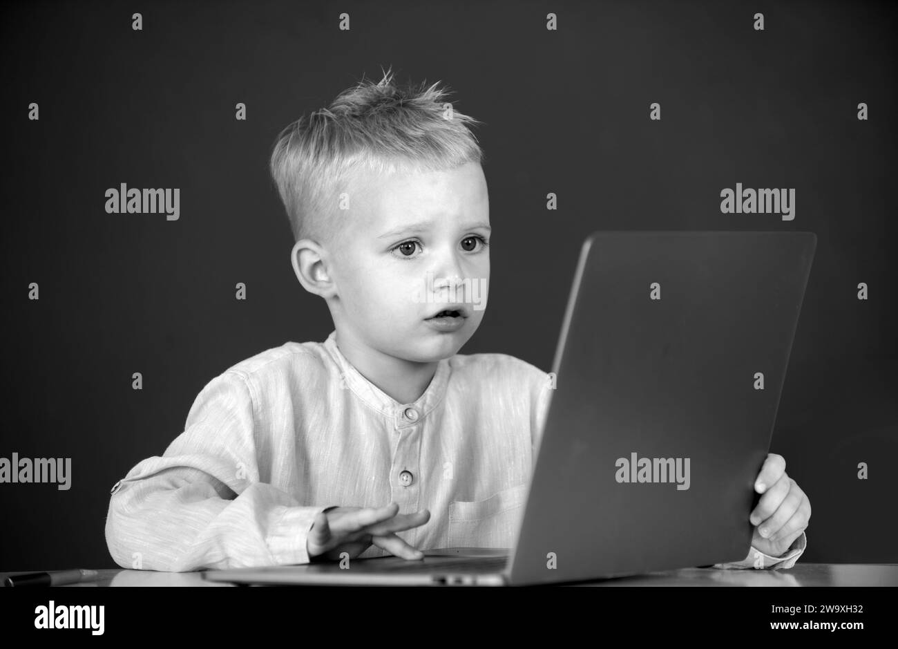 Serious concentrate little school kid boy study in a classroom. Little ...