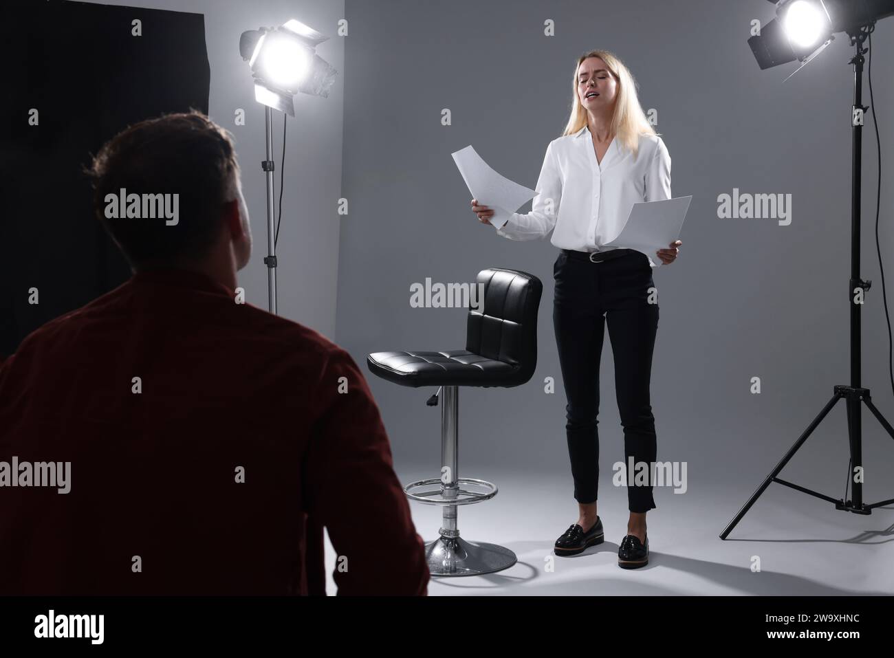 Emotional woman with script performing in front of casting director ...