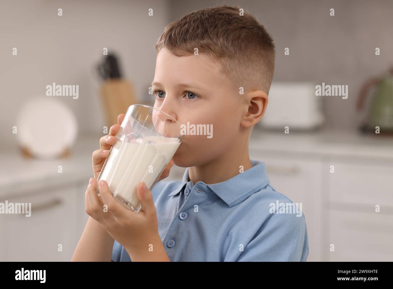 Cute boy drinking fresh milk from glass indoors Stock Photo - Alamy