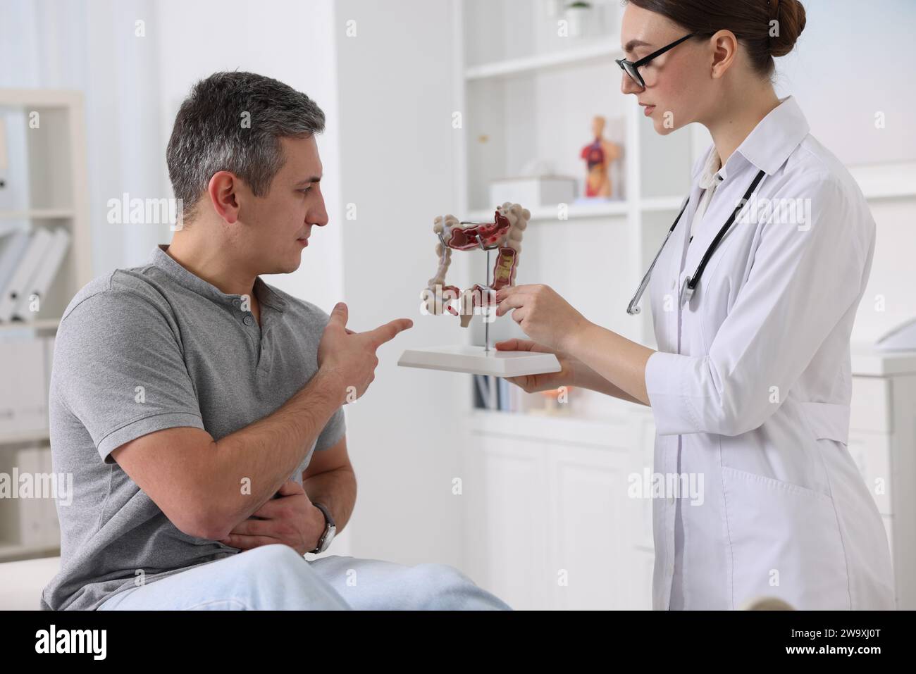Gastroenterologist with anatomical model of large intestine consulting ...