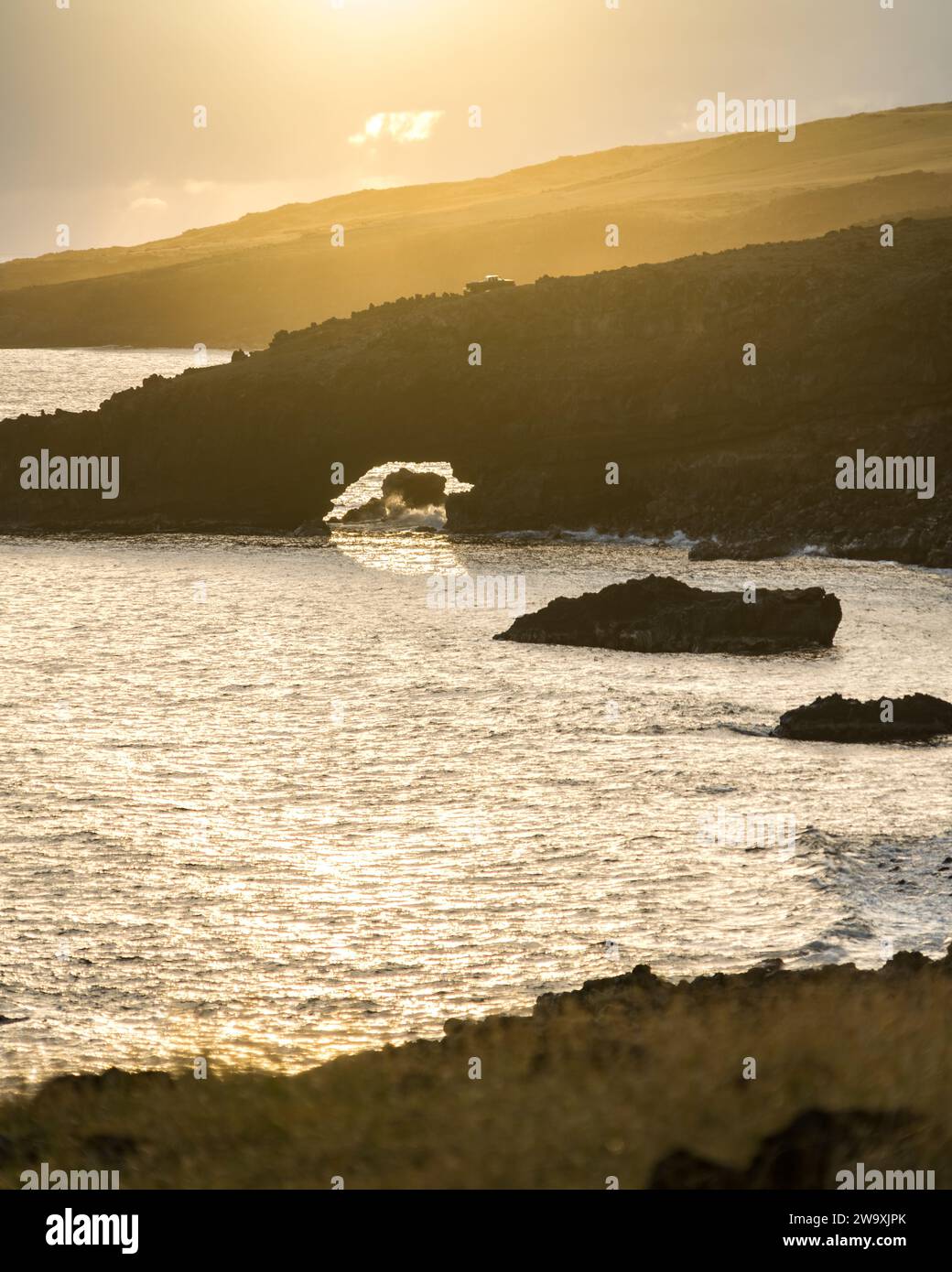 Golden sunset lights the rugged coastline of Maui along Piilani Highway ...