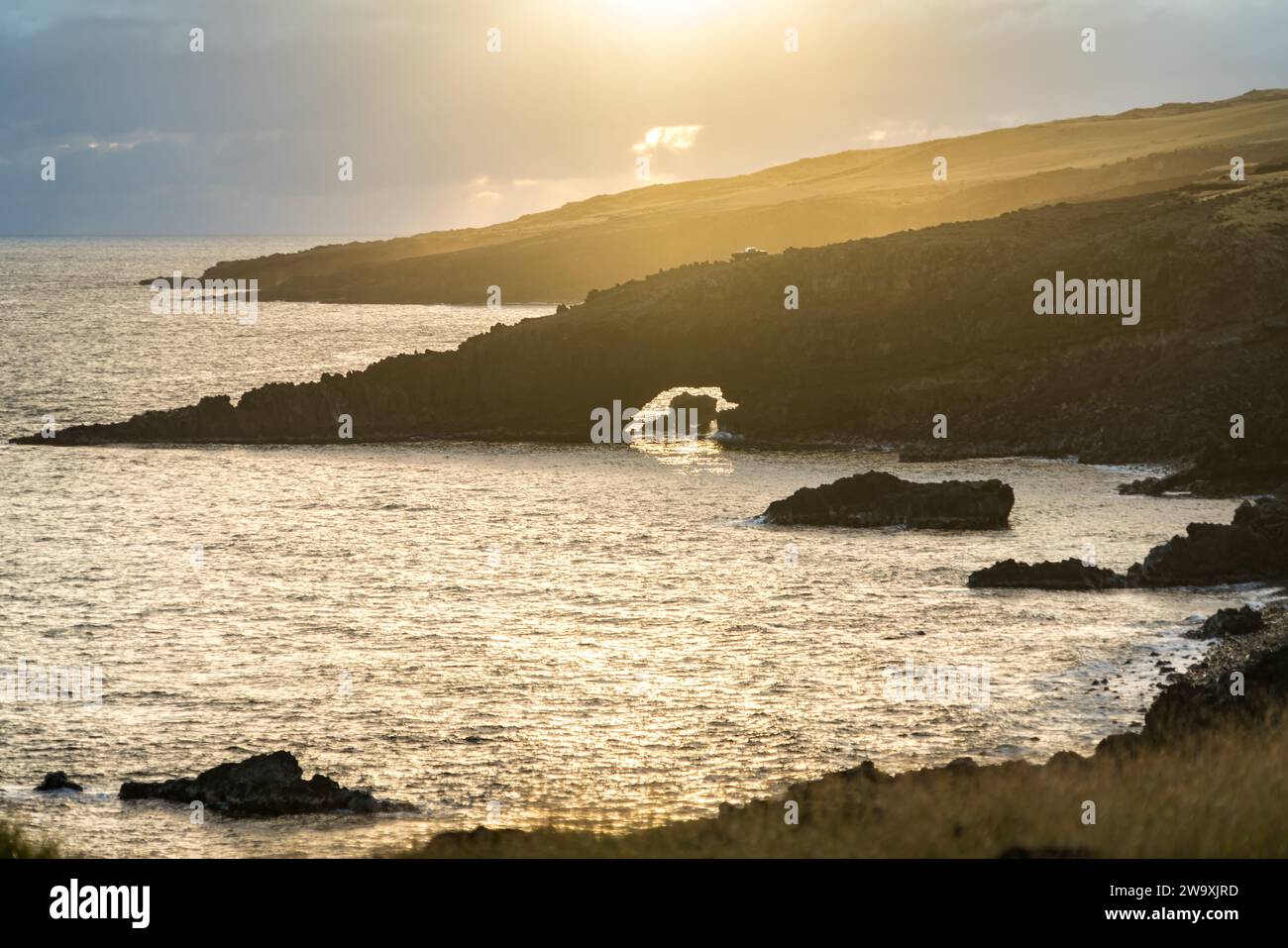 Golden sunset lights the rugged coastline of Maui along Piilani Highway ...