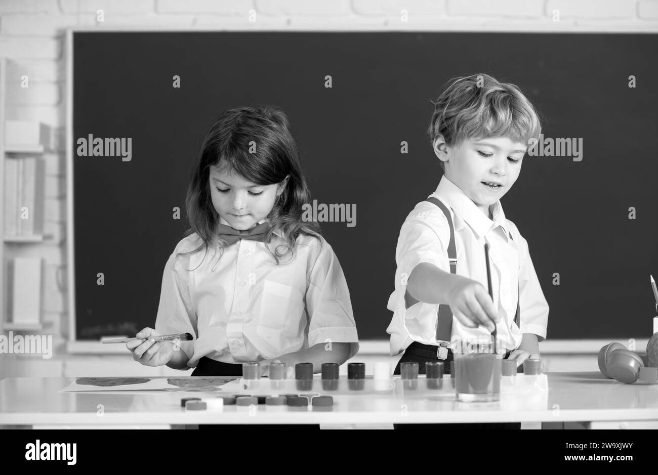 School children drawing a colorful pictures with pencil crayons in ...