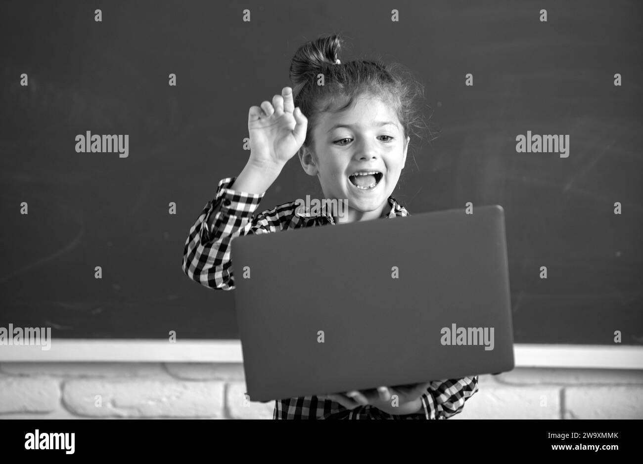 Excited student girl using laptop computer in school class on ...