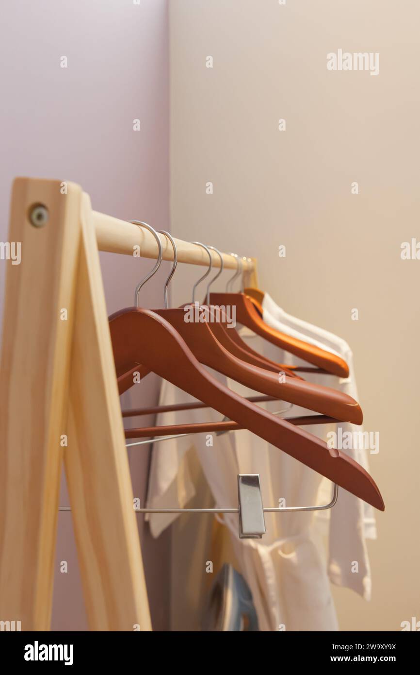 Group of empty wooden hanger on the rod Stock Photo - Alamy