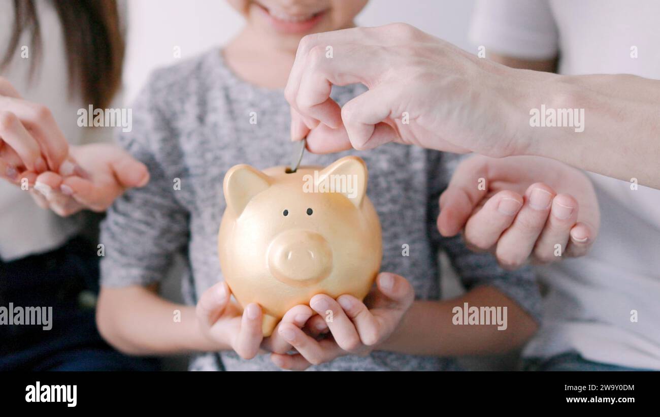 Happy family hands holding piggy bank. kid and parents put coins into ...