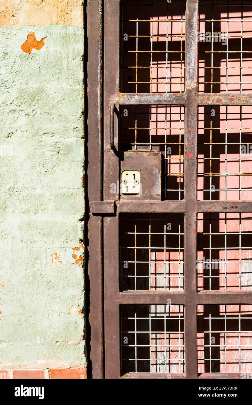 Old locked rusting metal jail style door Stock Photo - Alamy